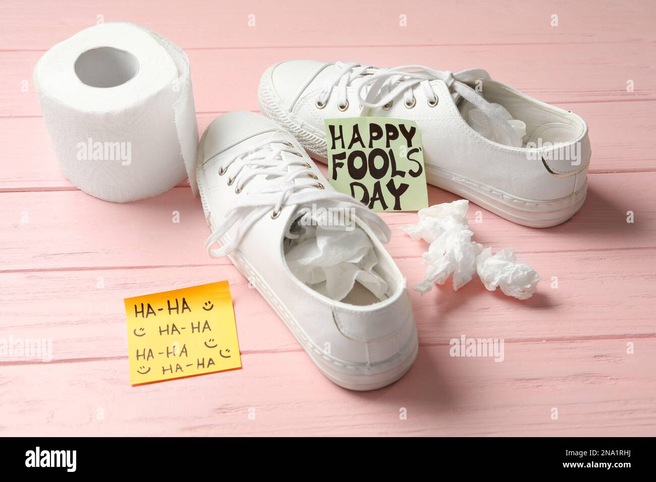 Shoes with toilet paper and Happy Fools' Day note on pink wooden ...