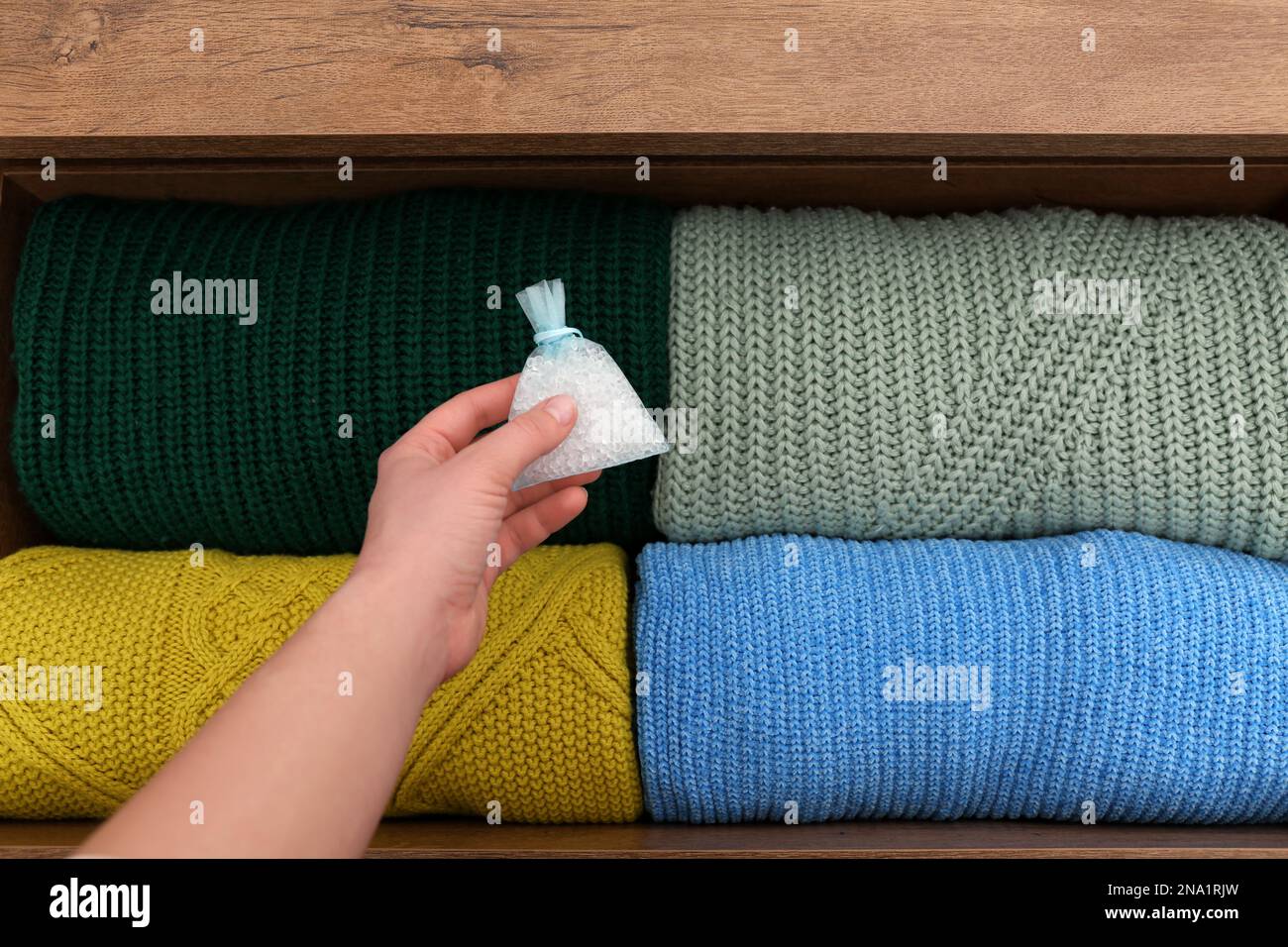 Woman putting scented sachet into drawer with clothes, closeup Stock ...
