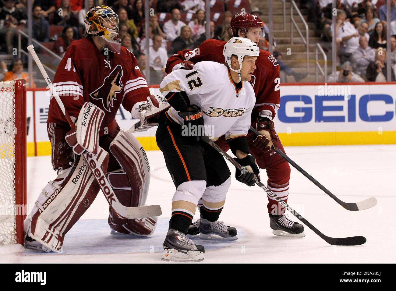 Phoenix Coyotes' Mike Smith, left, tries to find the puck as Coyotes ...