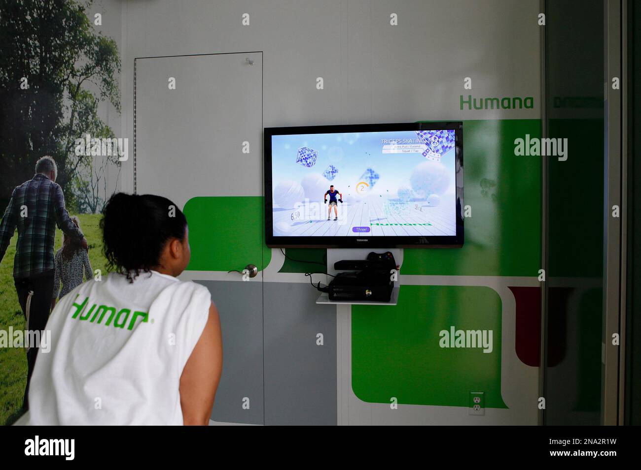 A worker demonstrates playing the Humana co-branded Your Shape: Fitness ...