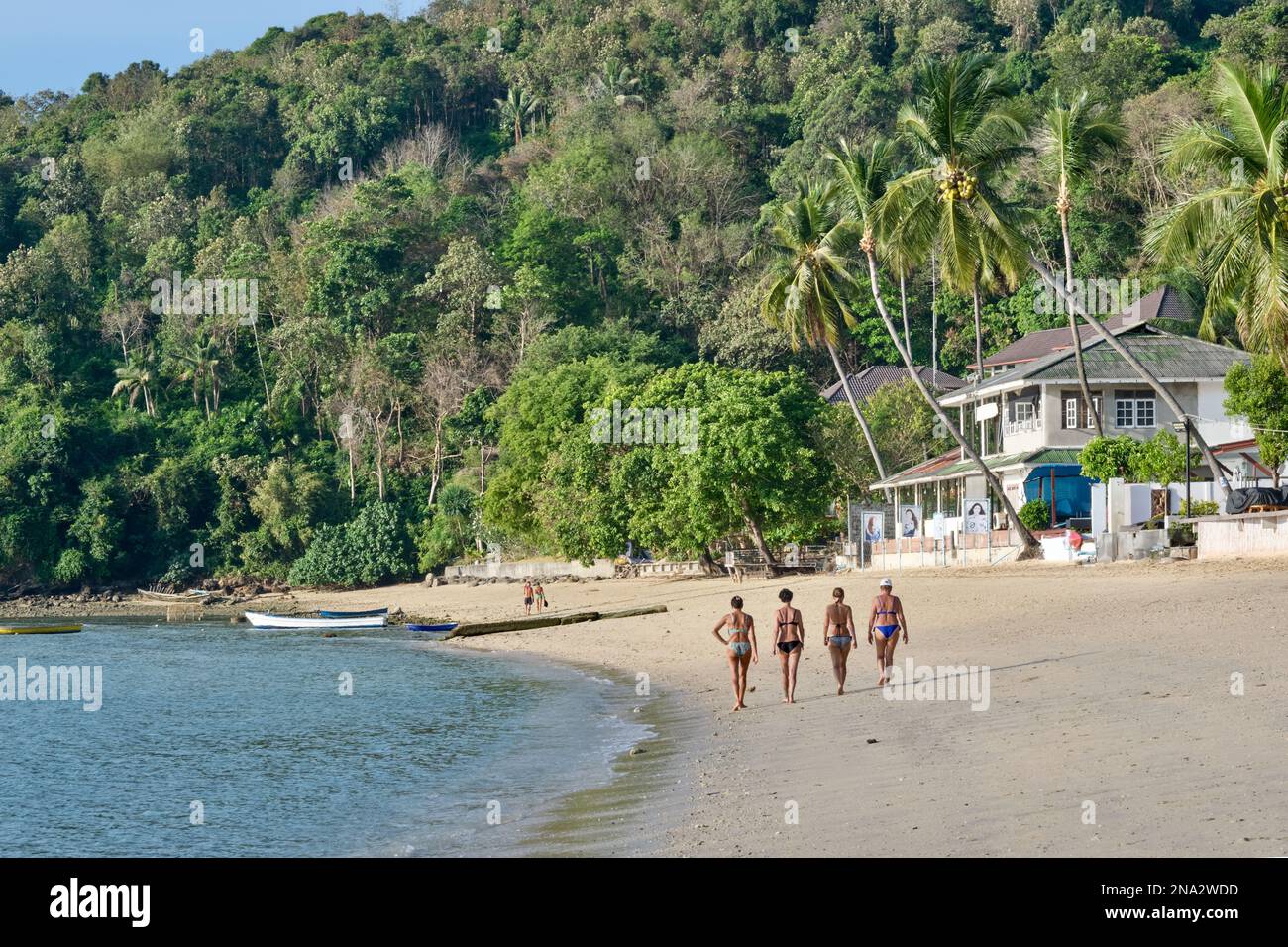 Four female Western tourists walk along a beach in secluded Ao Yon Bay ...