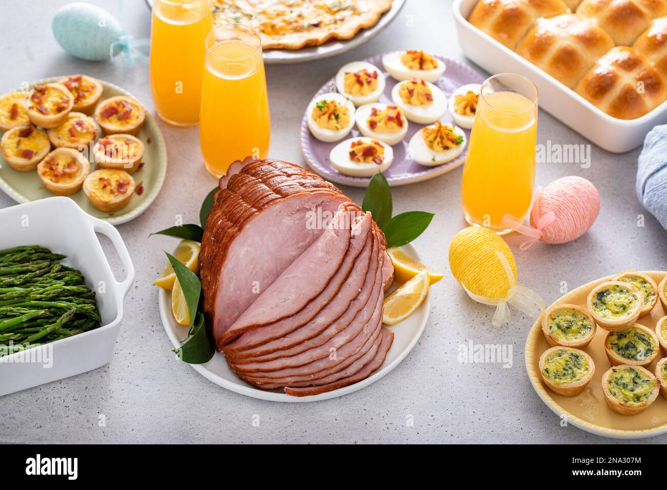 Easter brunch table with ham, quiche, hot cross buns and deviled eggs ...
