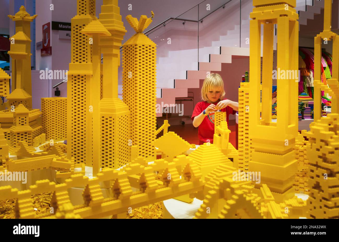 Boy building Lego tower in the Red Zone of the Lego House; Billund ...