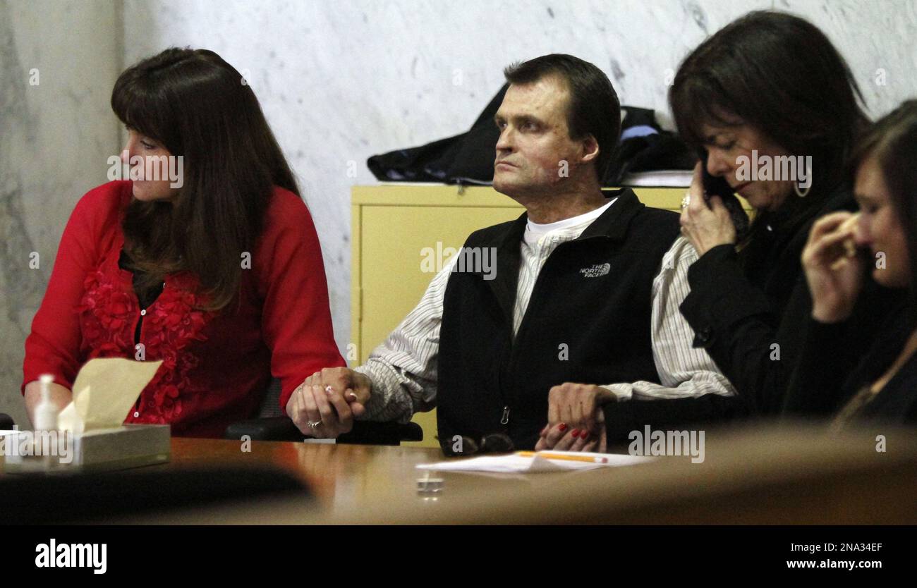 William Coultas, second from left, holds hands with his wife, Chris ...