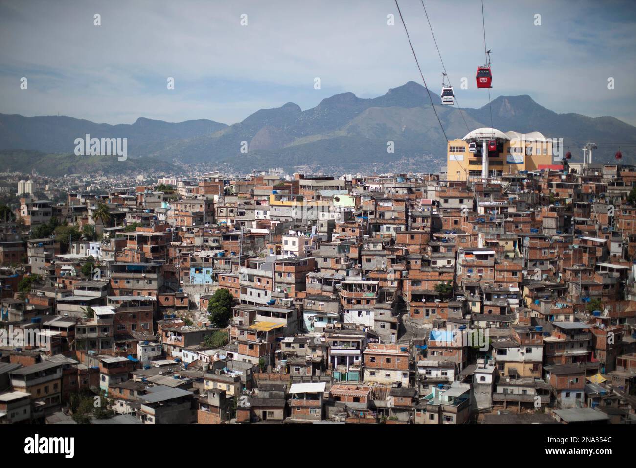 Cable cars travel over the Complexo do Alemao slum where military ...