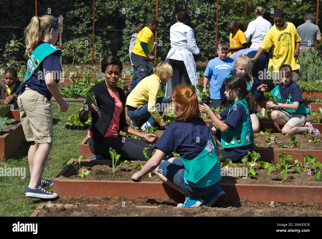 First lady Michelle Obama, second left, plants mustard seedlings with ...