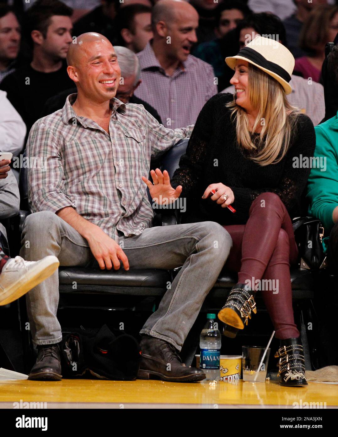 Actress Kaley Cuoco playfully taunts an unidentified man while cheering ...
