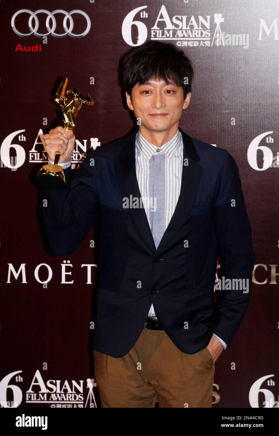 Taiwan actor Lawrence Ko poses with his trophy after he was awarded the ...