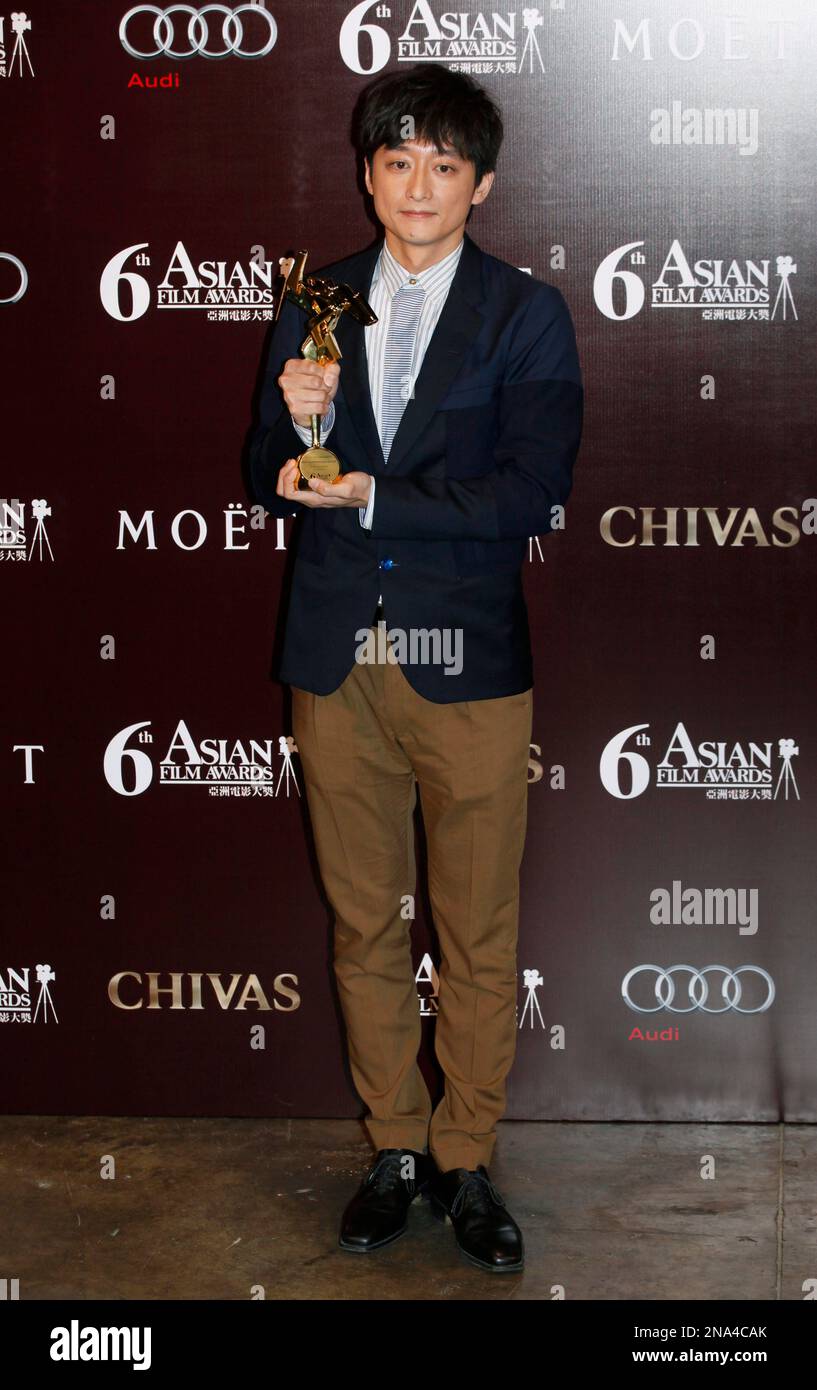 Taiwan actor Lawrence Ko poses with his trophy after he was awarded the ...