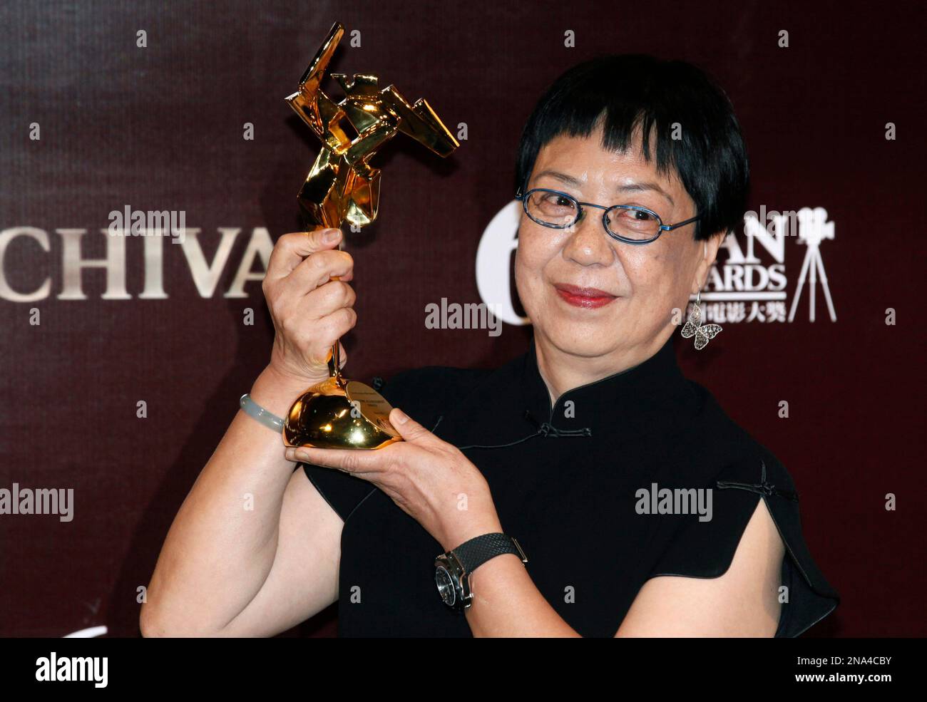 Hong Kong director Ann Hui poses with her trophy after receiving the ...