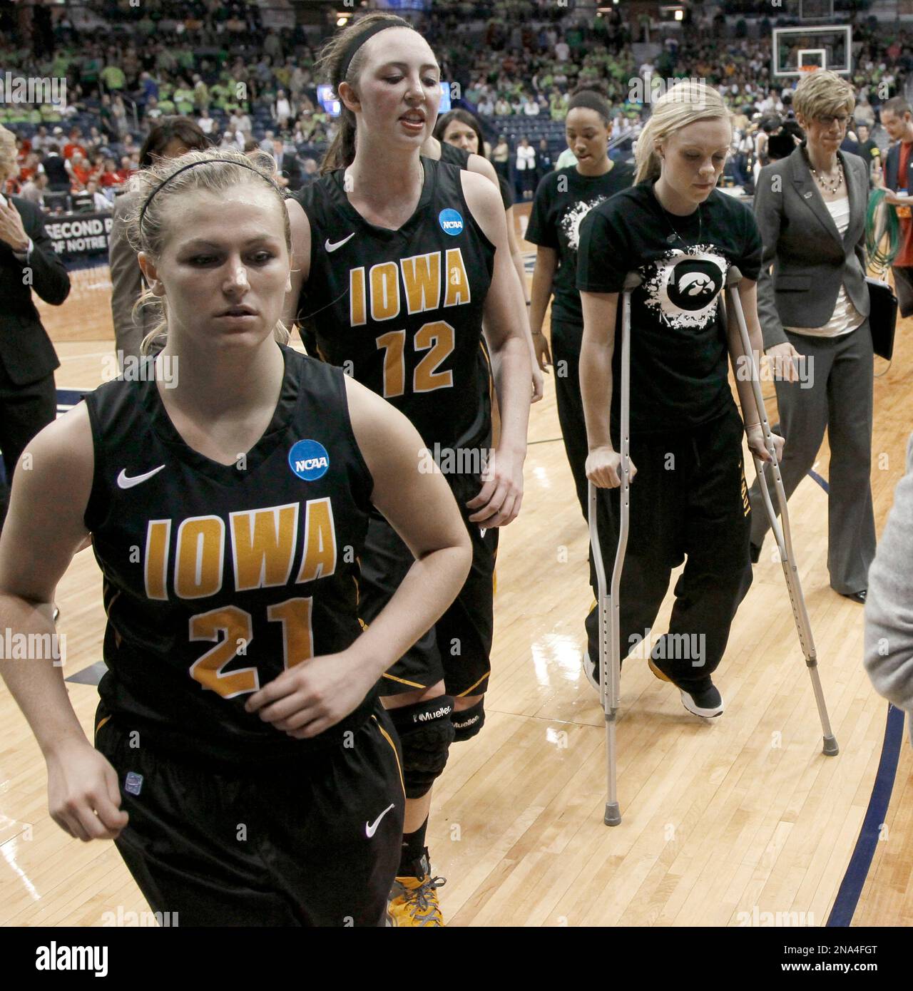 Injured Iowa guard Jaime Printy, right, walks off the court with ...
