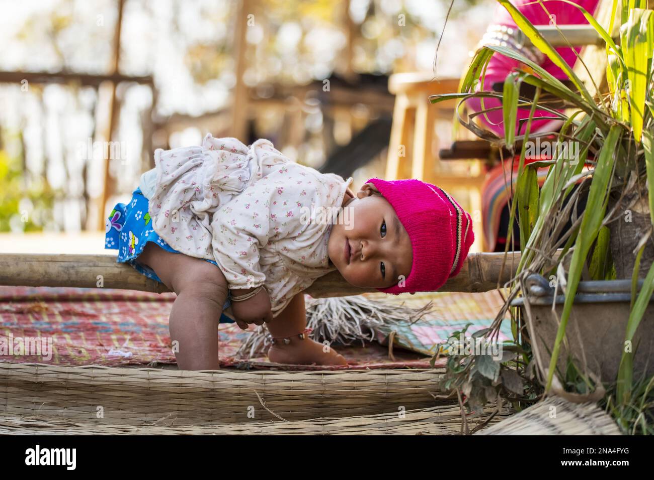 Adorable Thai baby posing for the camera while sitting and laying her ...