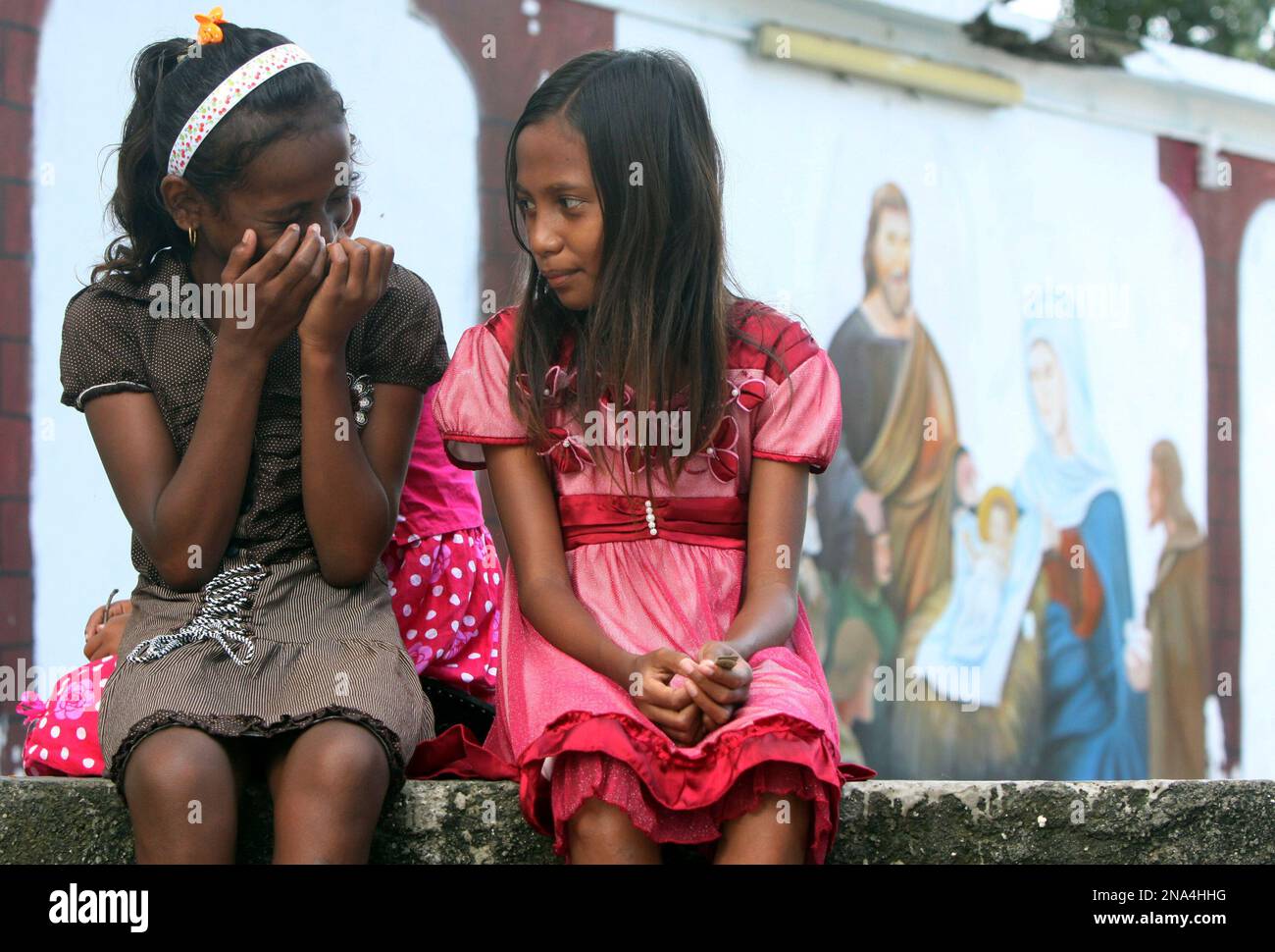 East Timorese girls attend a mass held outside a church in Dili, East ...