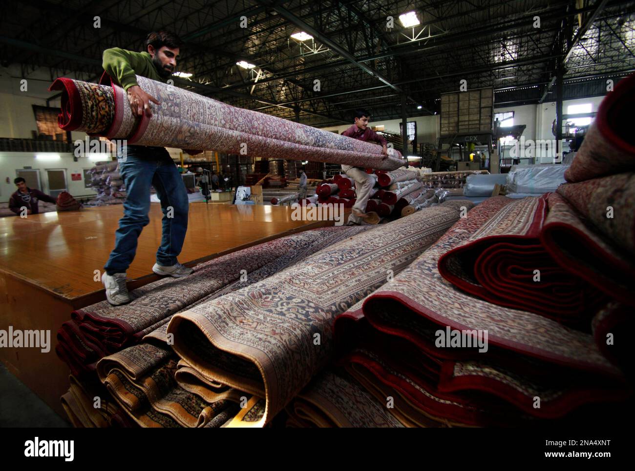 In this Thursday, March 15, 2012 photo, Indian workers carry finished ...