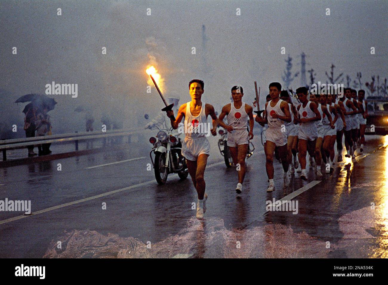 Japanese torchbearers of the Olympic flame relay team run through the ...