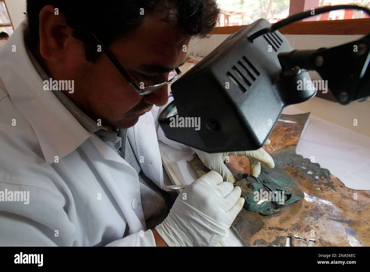 A restorer works on a diadem that was discovered in the 1,500-year-old ...