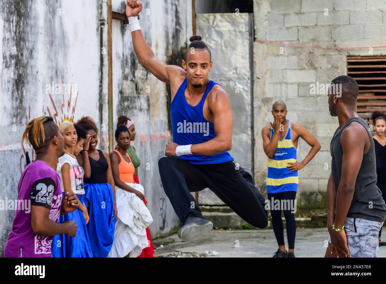 Young Cuban men dancing in an old concrete building with graffiti on ...