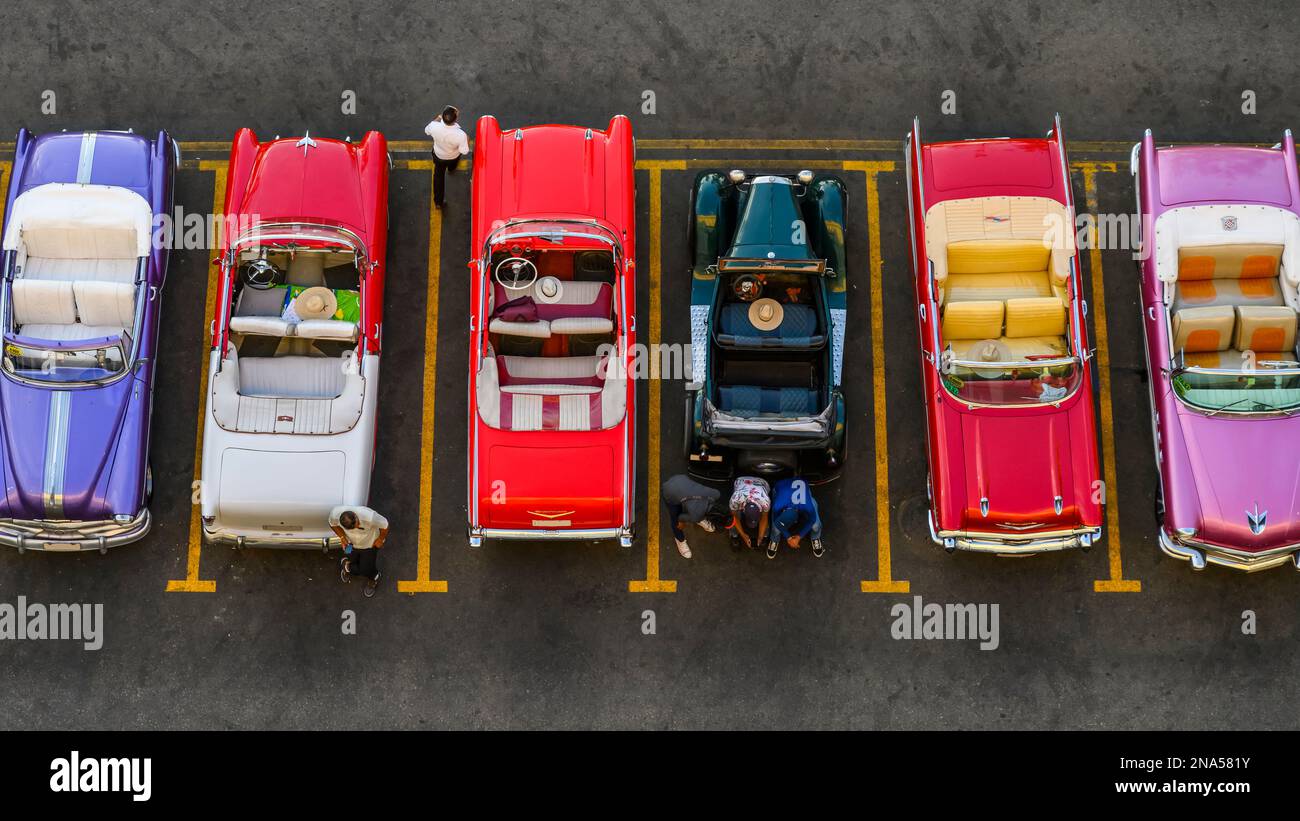 Vintage convertible cars parked in a row in a parking lot; Havana, Cuba ...