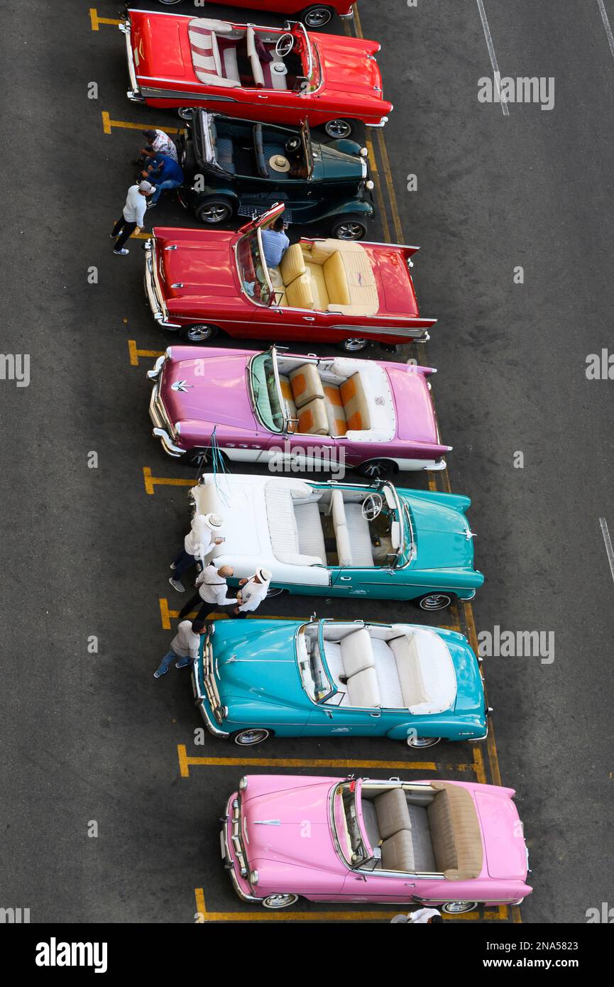 Vintage convertible cars parked in a row in a parking lot; Havana, Cuba ...