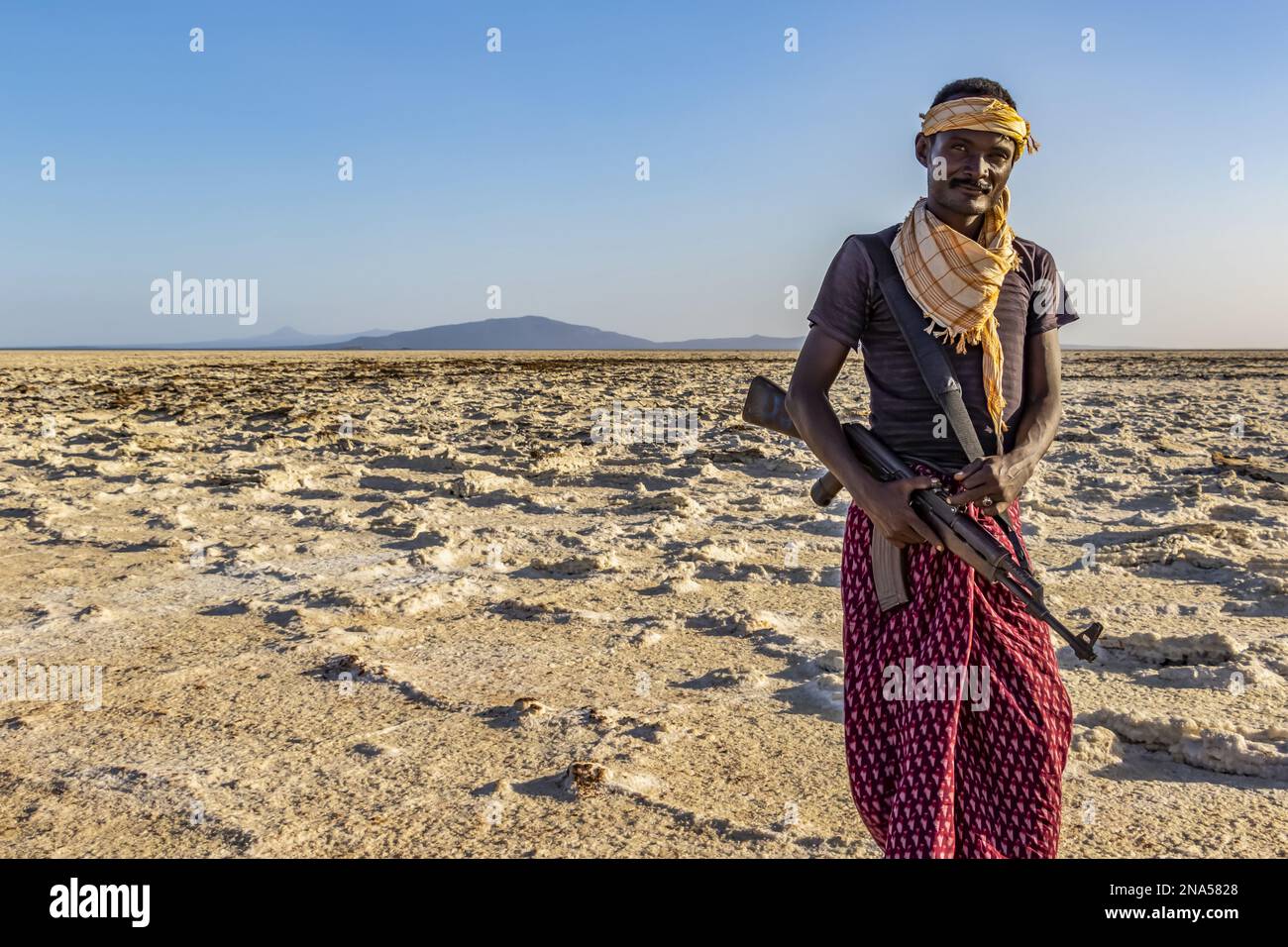 Afar man carrying a gun in the salt flats of Lake Karum (Lake Assale ...