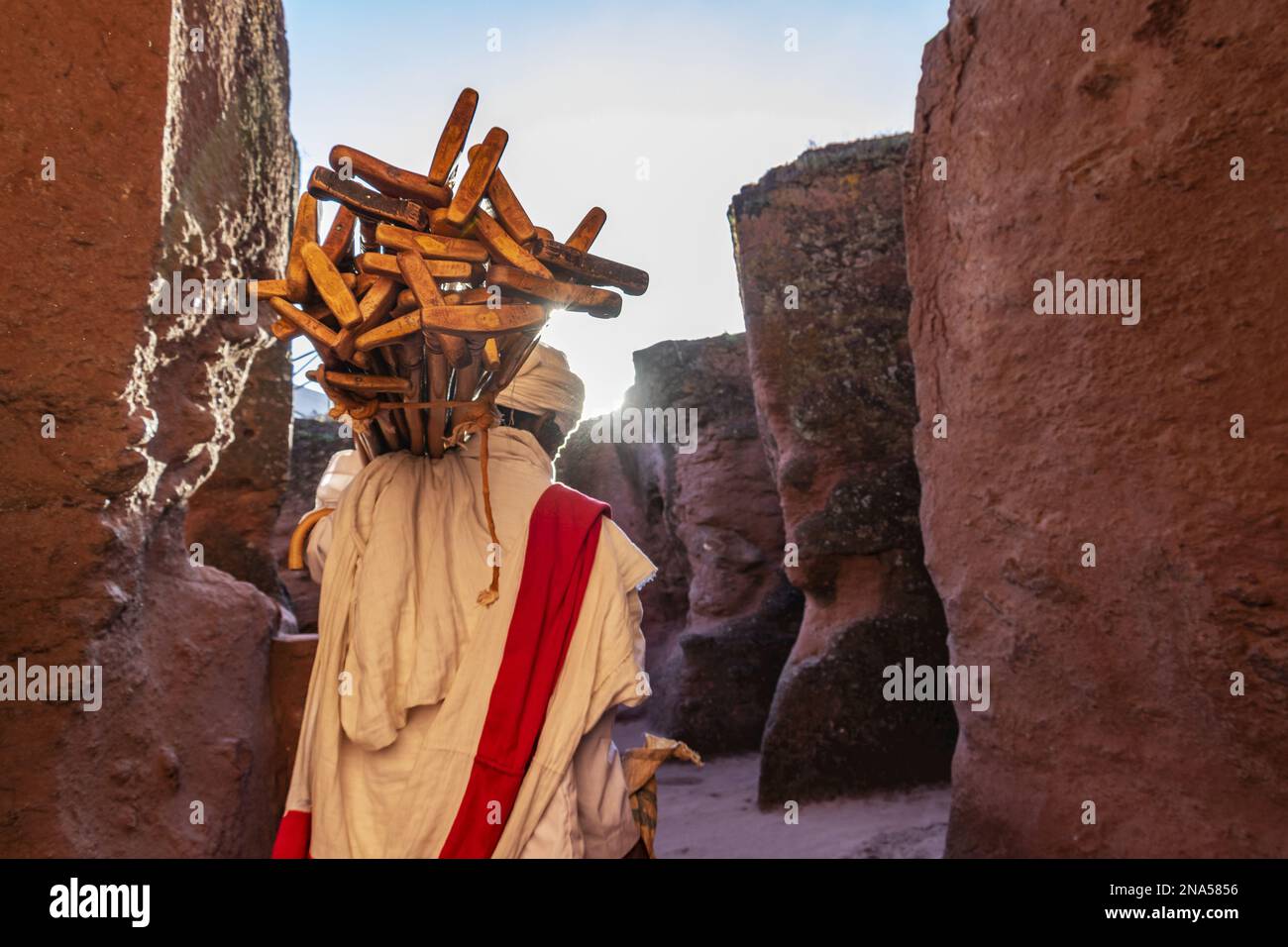 Ethiopian Orthodox priest carrying prayer sticks by Biete Qeddus ...