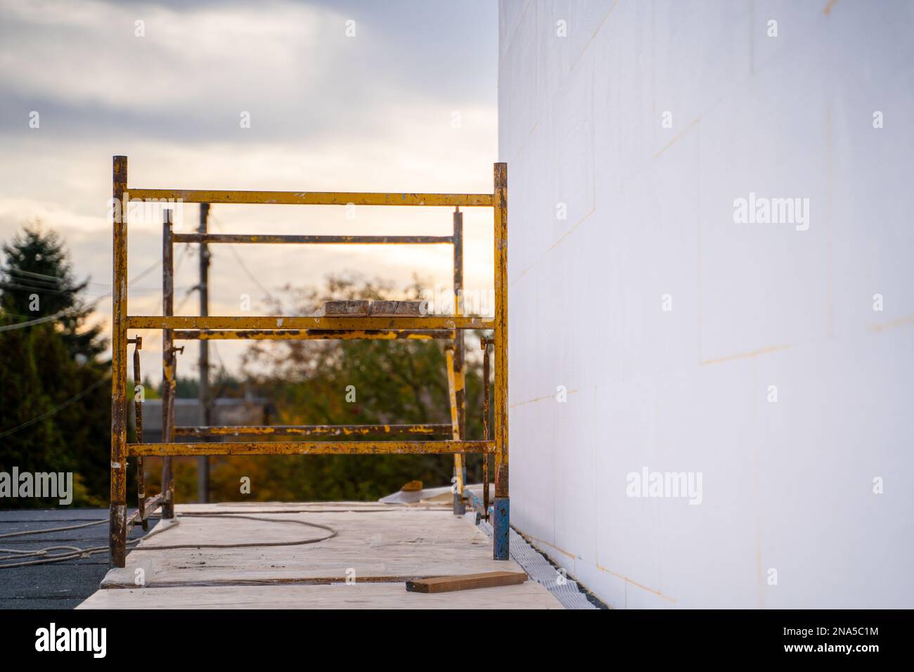 Scaffolding stands near the wall insulated with polystyrene foam ...