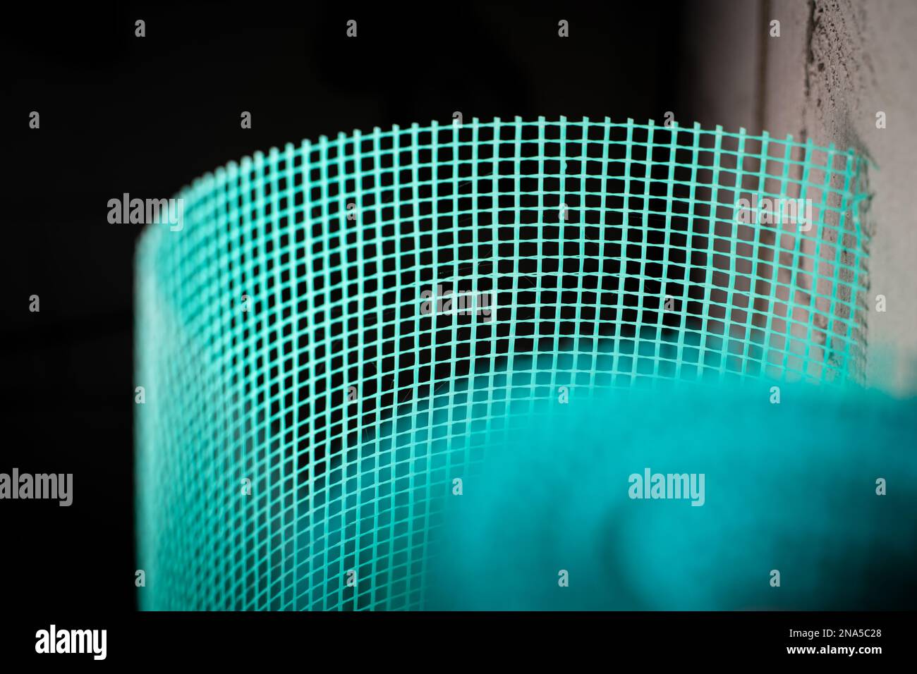 Green reinforcing mesh close-up. Facade fiberglass mesh on a blurred ...
