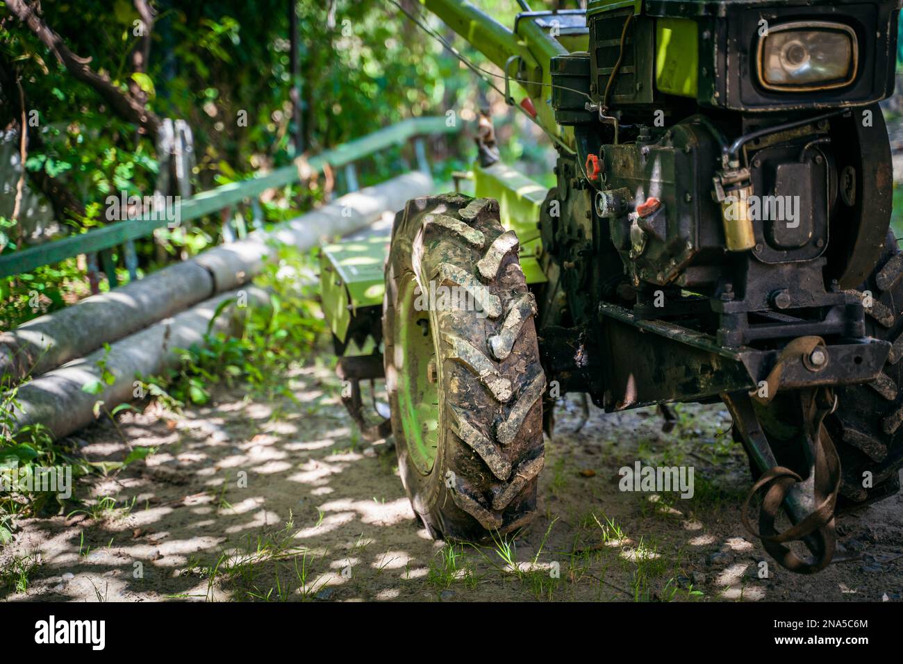 Walk-behind tractor with headlight close-up on a blurred background ...