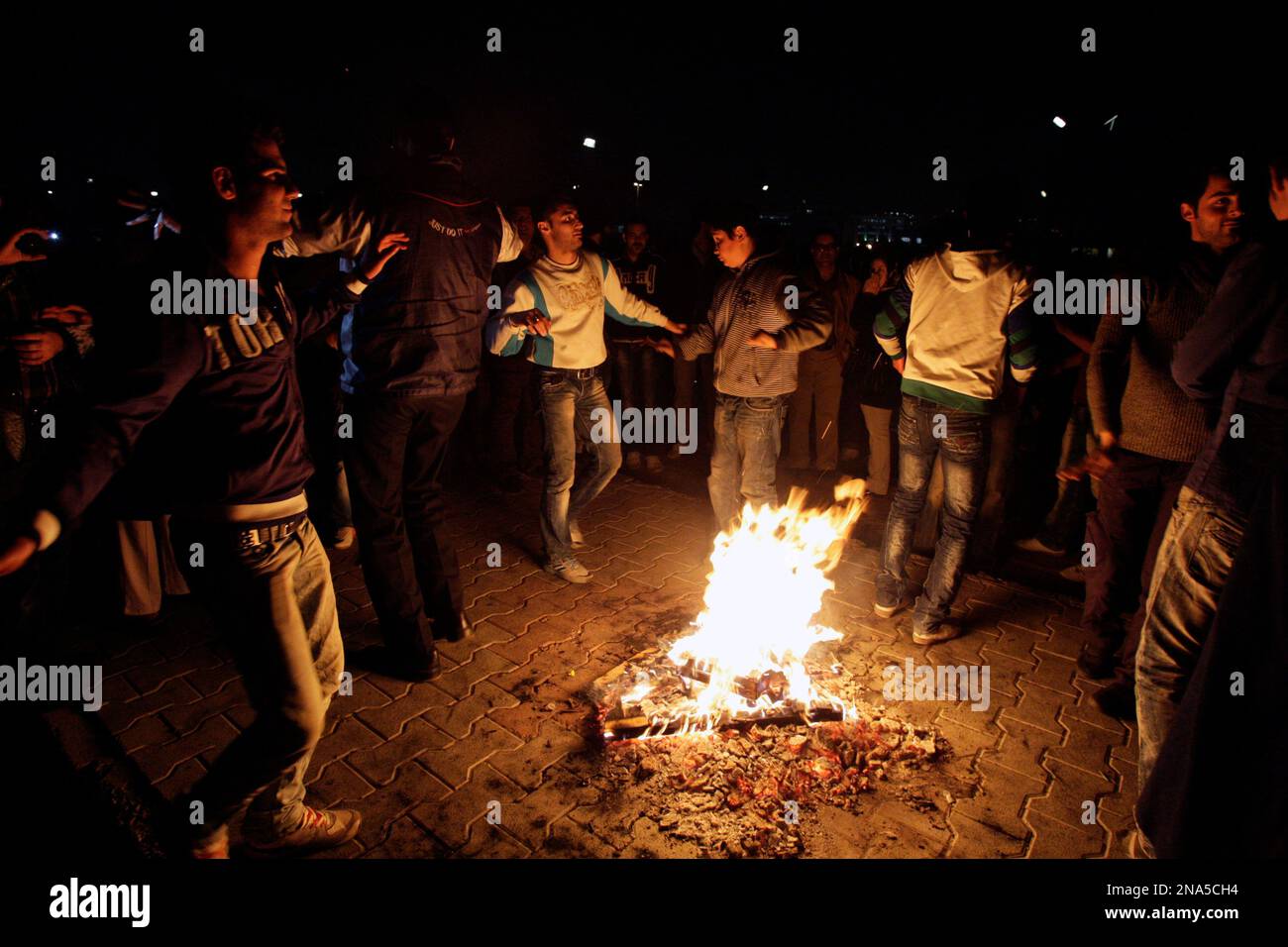 Joyful Iranian men dance around a bonfire, in the Pardisan Park in ...