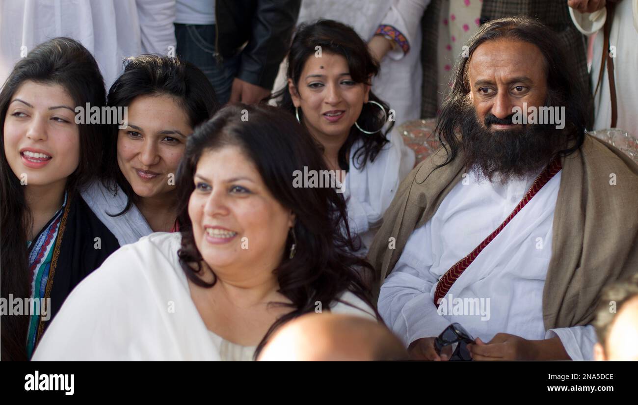 People pose with Indian visiting Guru Sri Sri Ravi Shankar, right, for ...