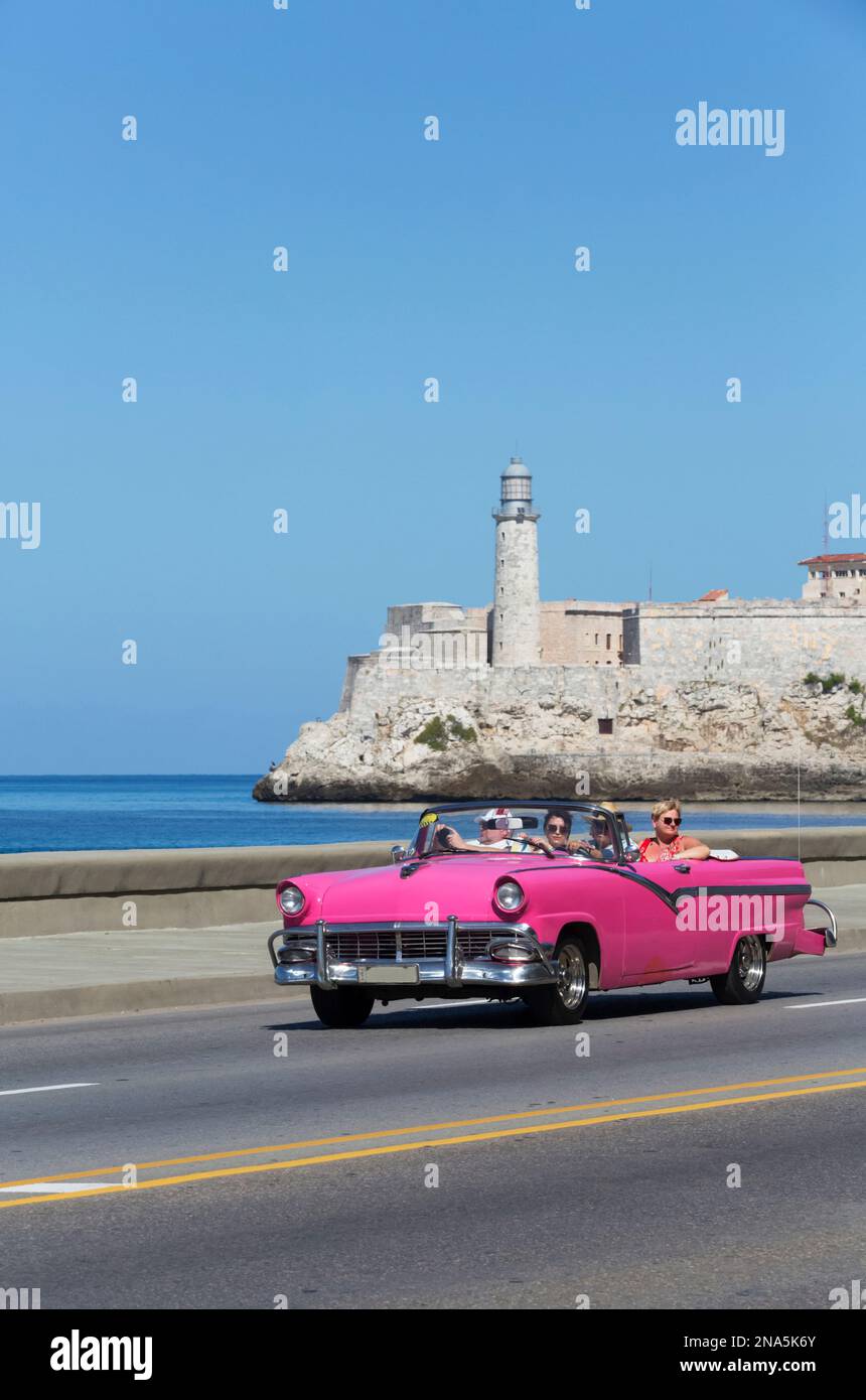 Old classic pink convertible car on the Malecon, Castillo del Morro ...