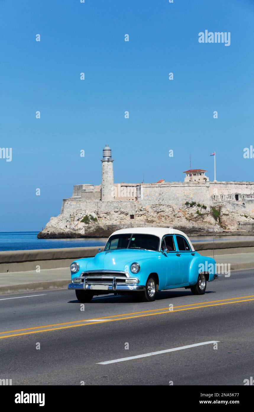 Old classic car on the Malecon, Castillo del Morro (background); Havana ...