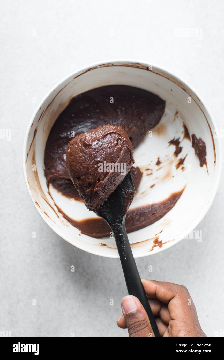 Thick chocolate madeleine batter that has rested in a white bowl, thick ...