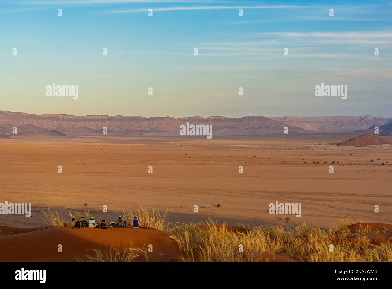 Tourists look out at the desert from Elim dune, Sesriem, Namib Desert ...