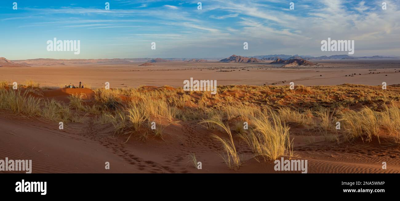Tourists look out at the desert from Elim dune, Sesriem, Namib Desert ...