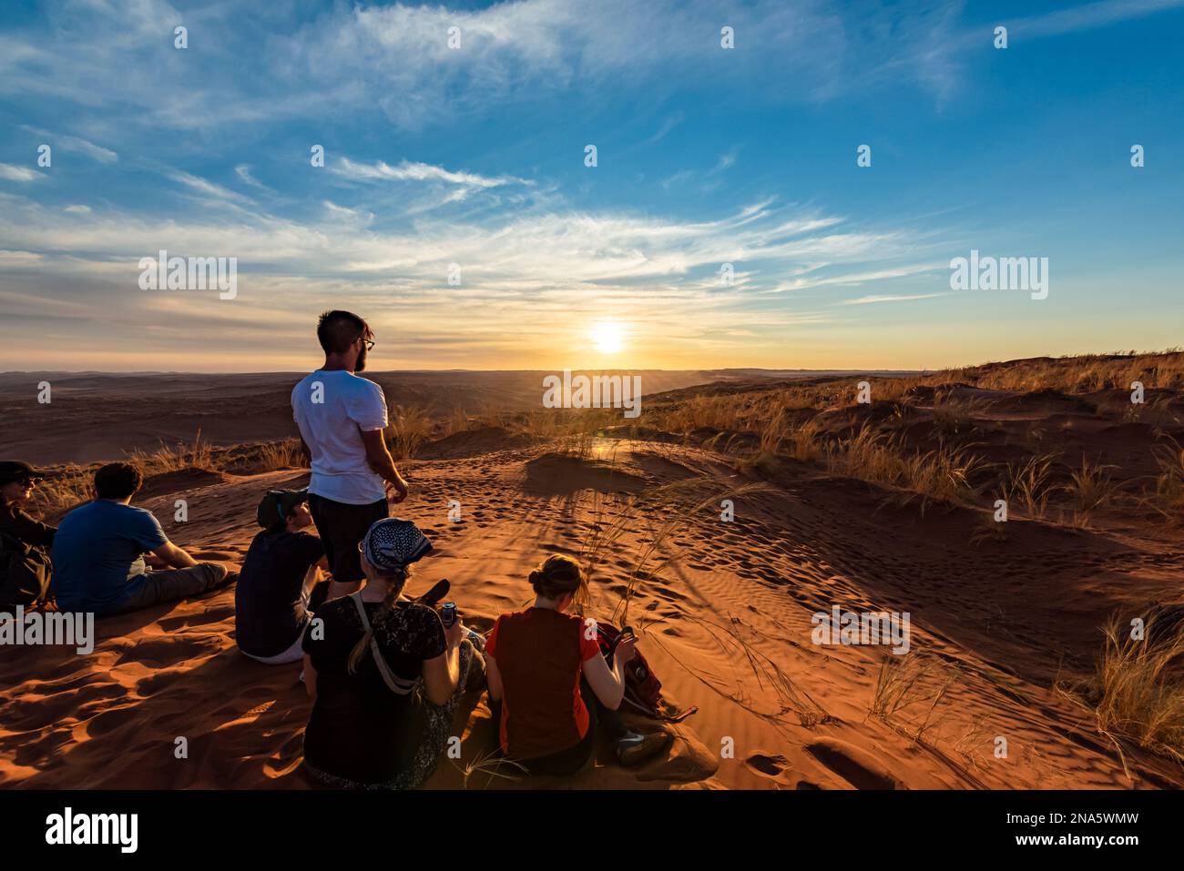 Tourists look out at the desert from Elim dune, Sesriem, Namib Desert ...