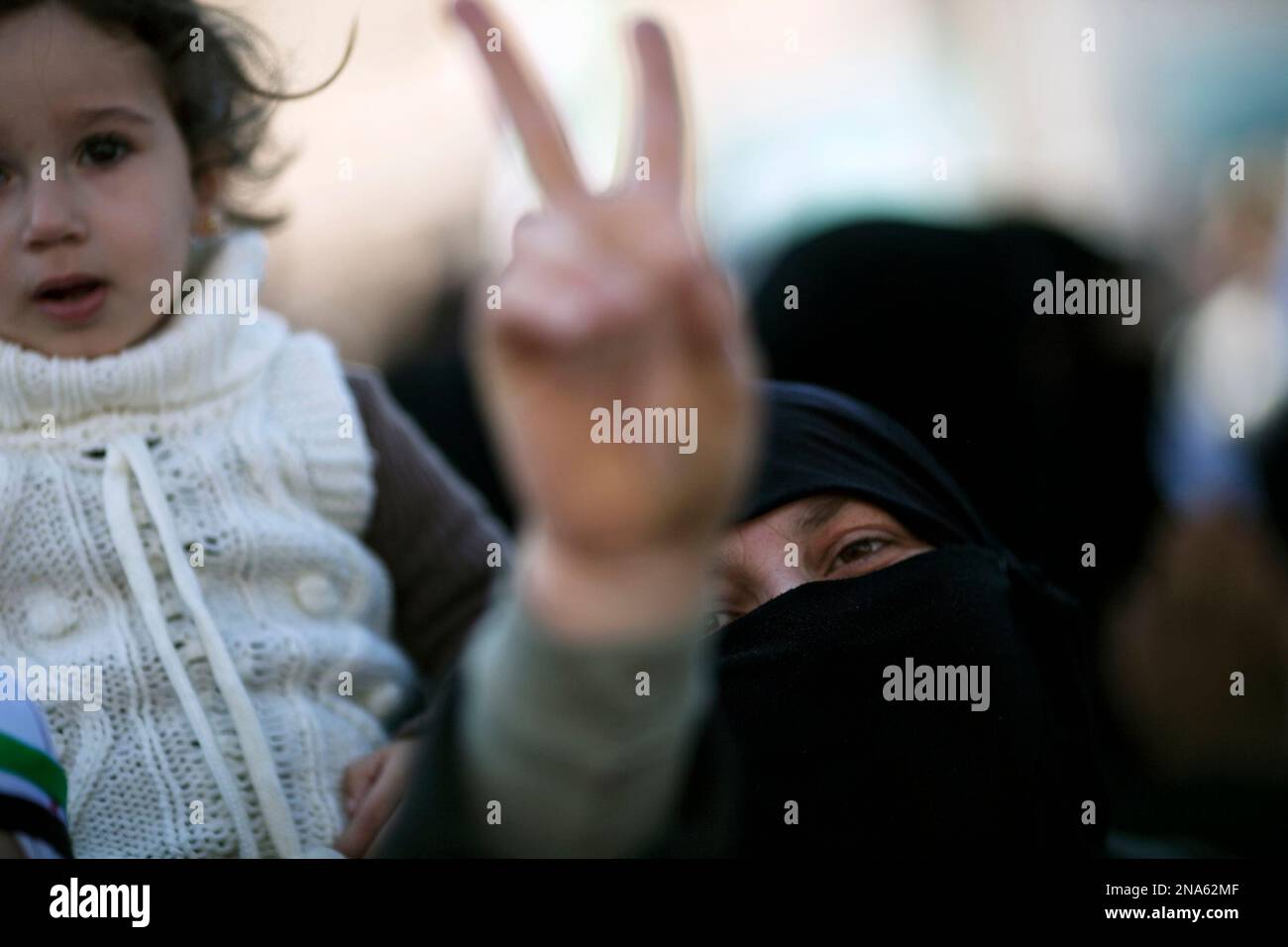 A woman displays a victory sign during an anti-government demonstration ...