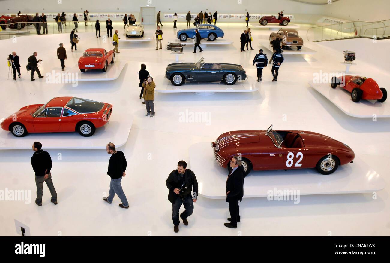 Visitors walk between vintage Farrari sport cars on display at the ...