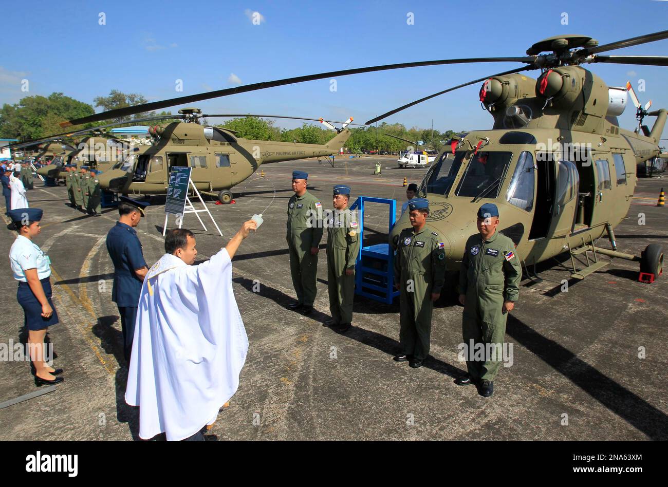 A military chaplain sprinkles Holy Water to brand new Polish Sokol Multi-role helicopters during ...