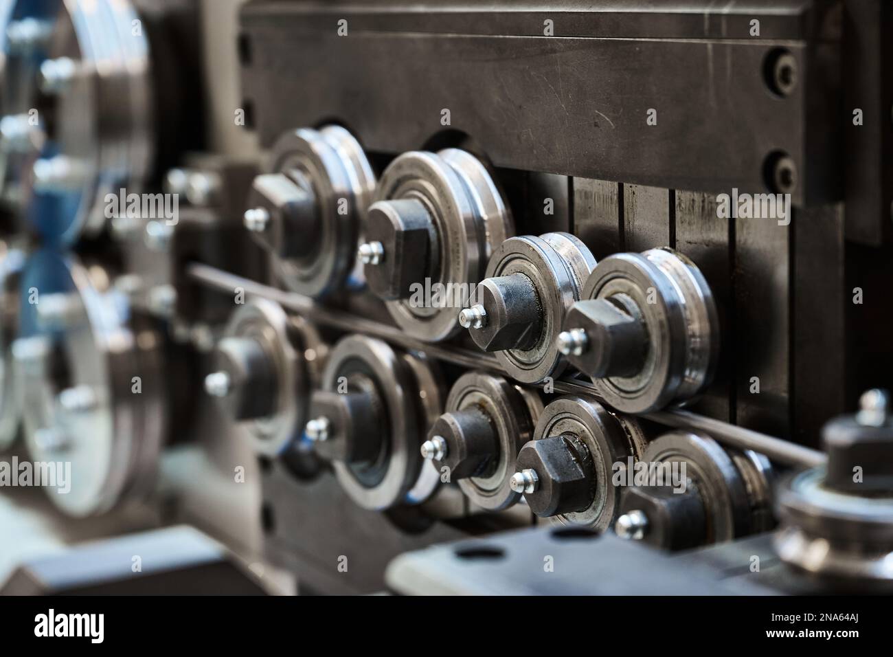 Metal cable pulled out through rollers line on machine tool Stock Photo ...