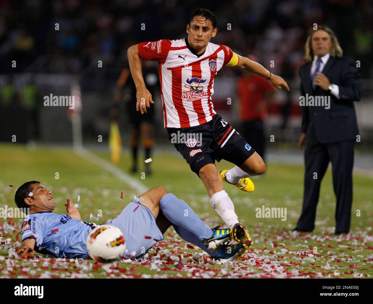 Colombia's Junior's Giovanni Hernandez, center, jumps over Bolivia's Bolivar's Walter Flores ...