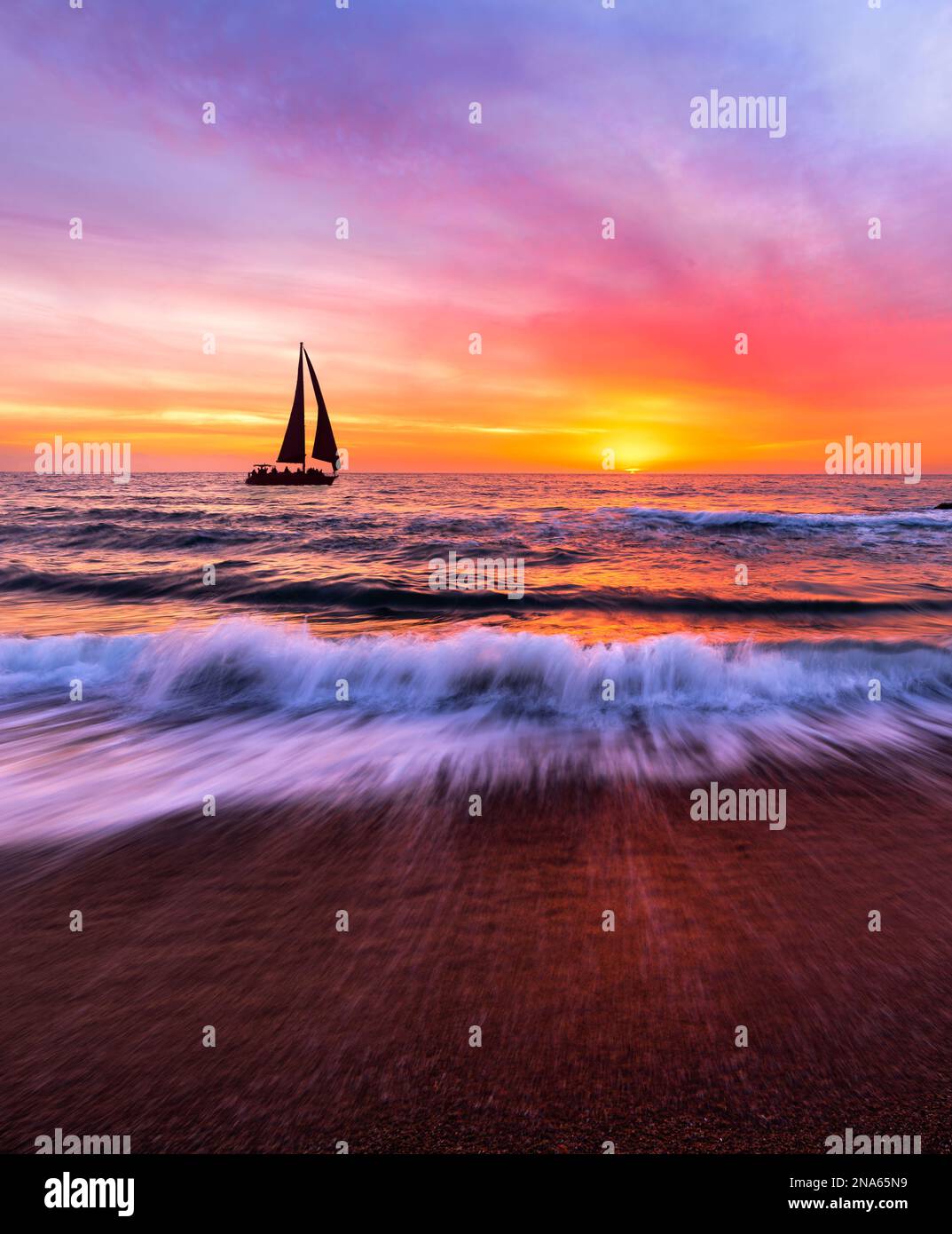 A Sailboat Is Sailing Along The Ocean With A Wave Breaking On Shore In ...