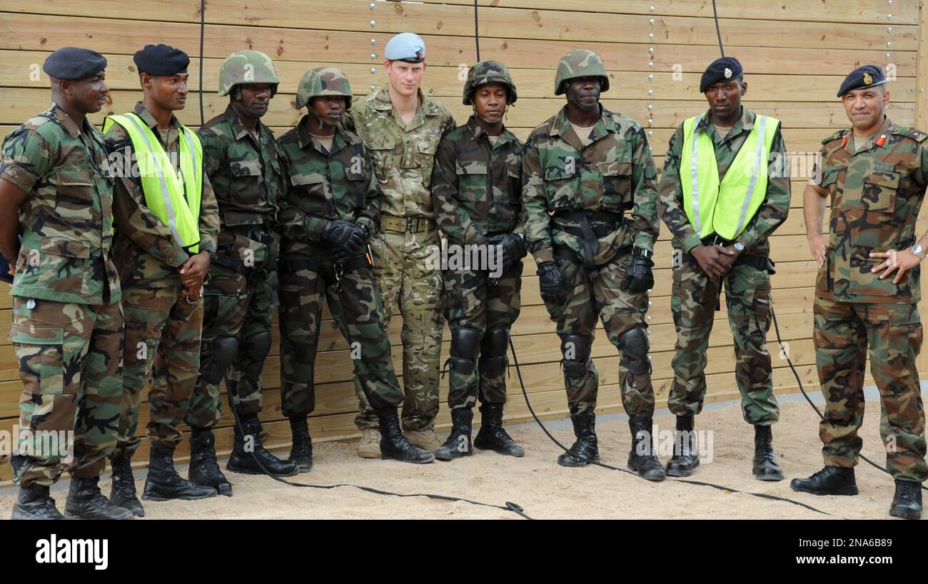 Britain's Prince Harry, center, poses with Jamaican soldiers before ...