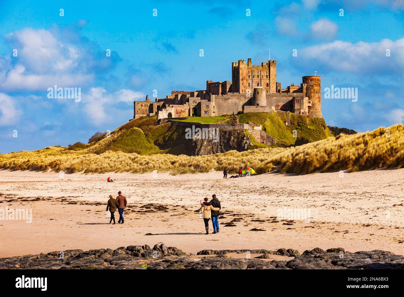 People on a beach near Lindisfarne Castle; Holy Island, Northumberland ...