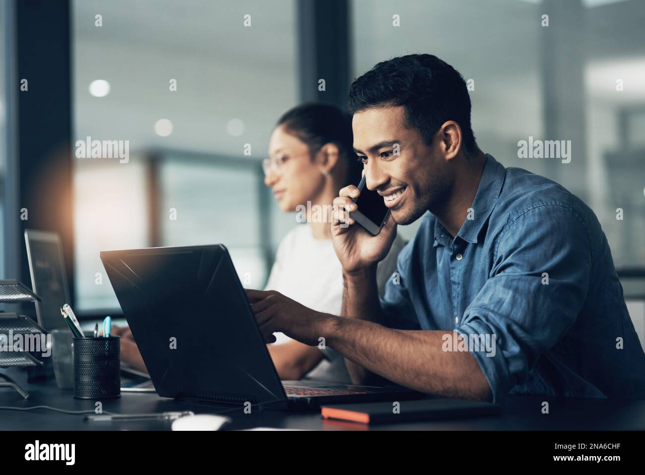 Inspired by the world. a young man using his cellphone while working on ...