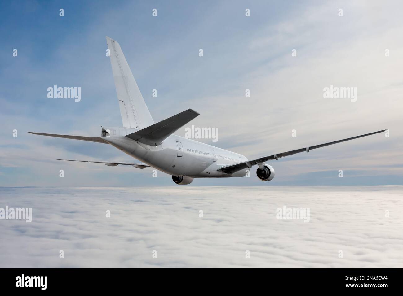 White wide body passenger airplane flying in the air above the clouds ...