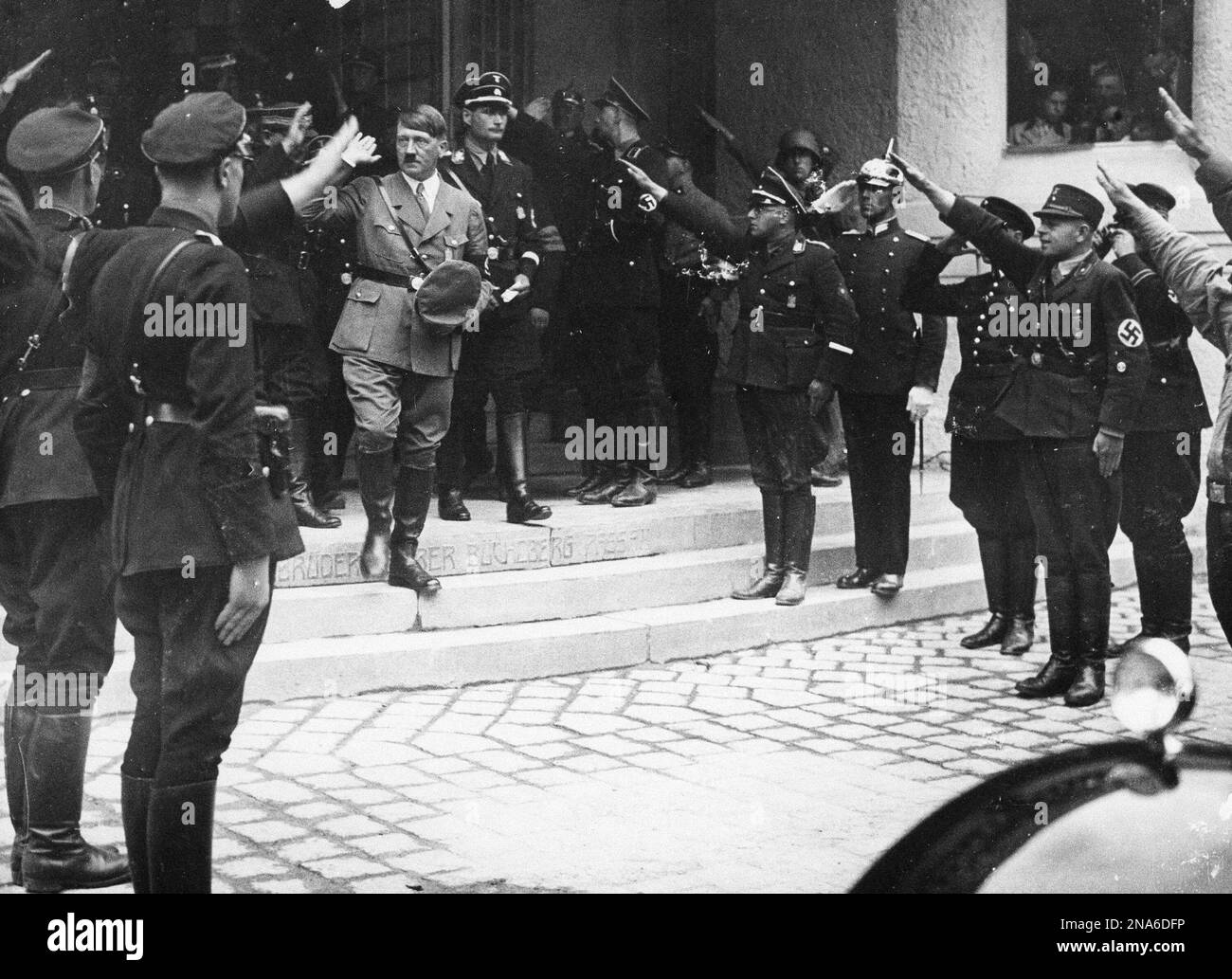 Chancellor Adolf Hitler returns the salute of Nazi troopers on leaving ...