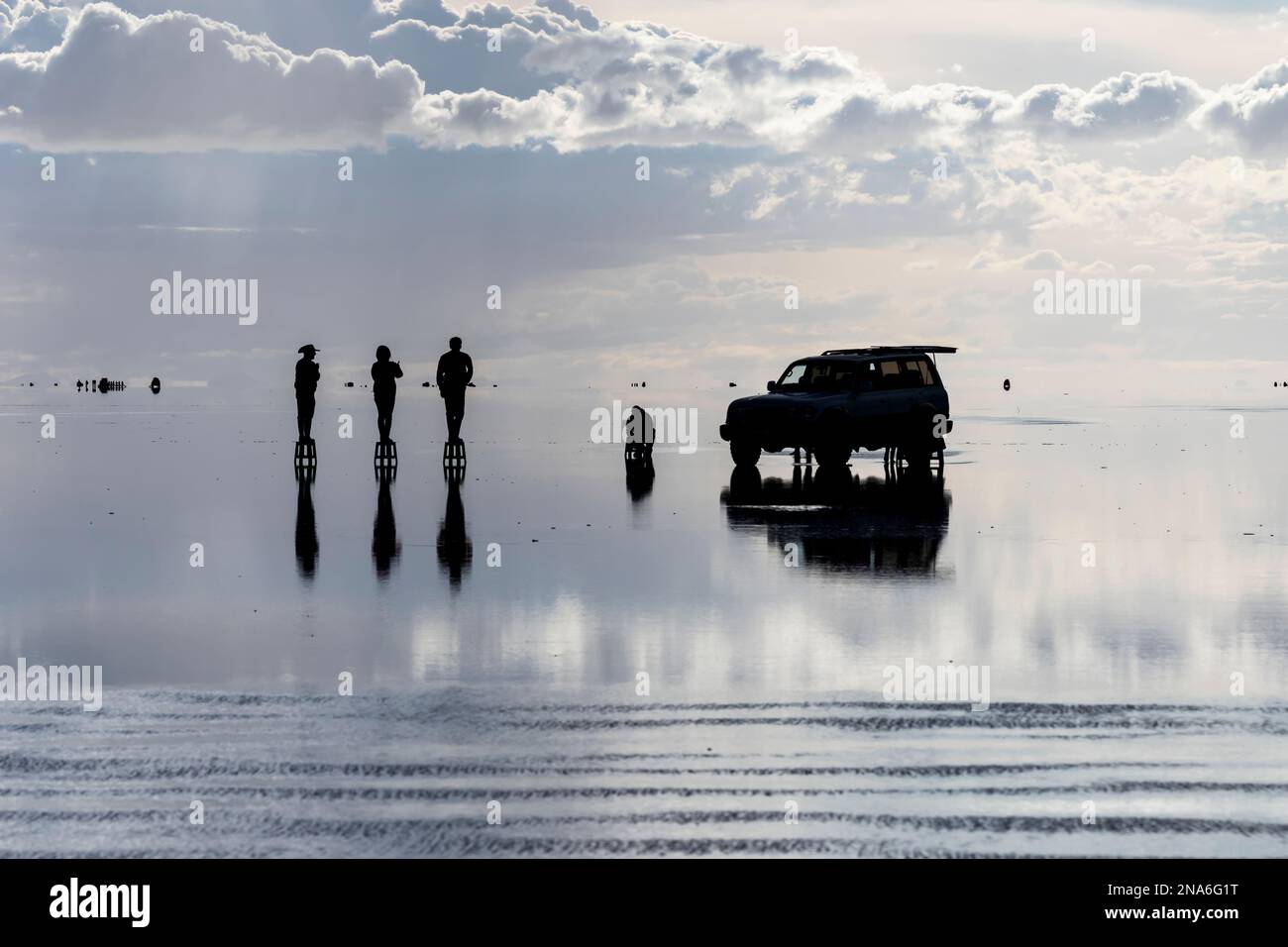 Tourists posing in the reflection during the wet season (December ...