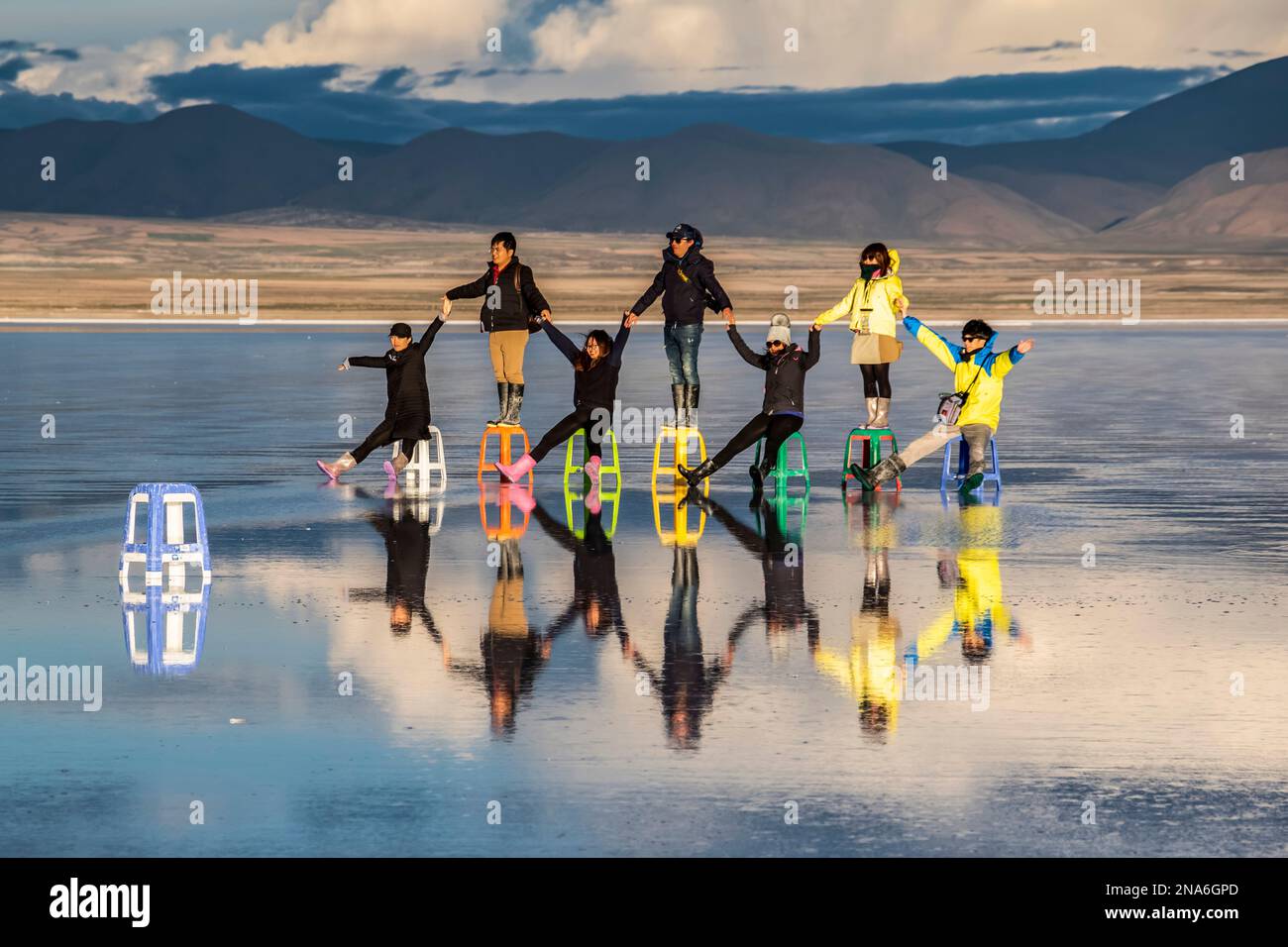 Tourists posing in the reflection during the wet season (December ...