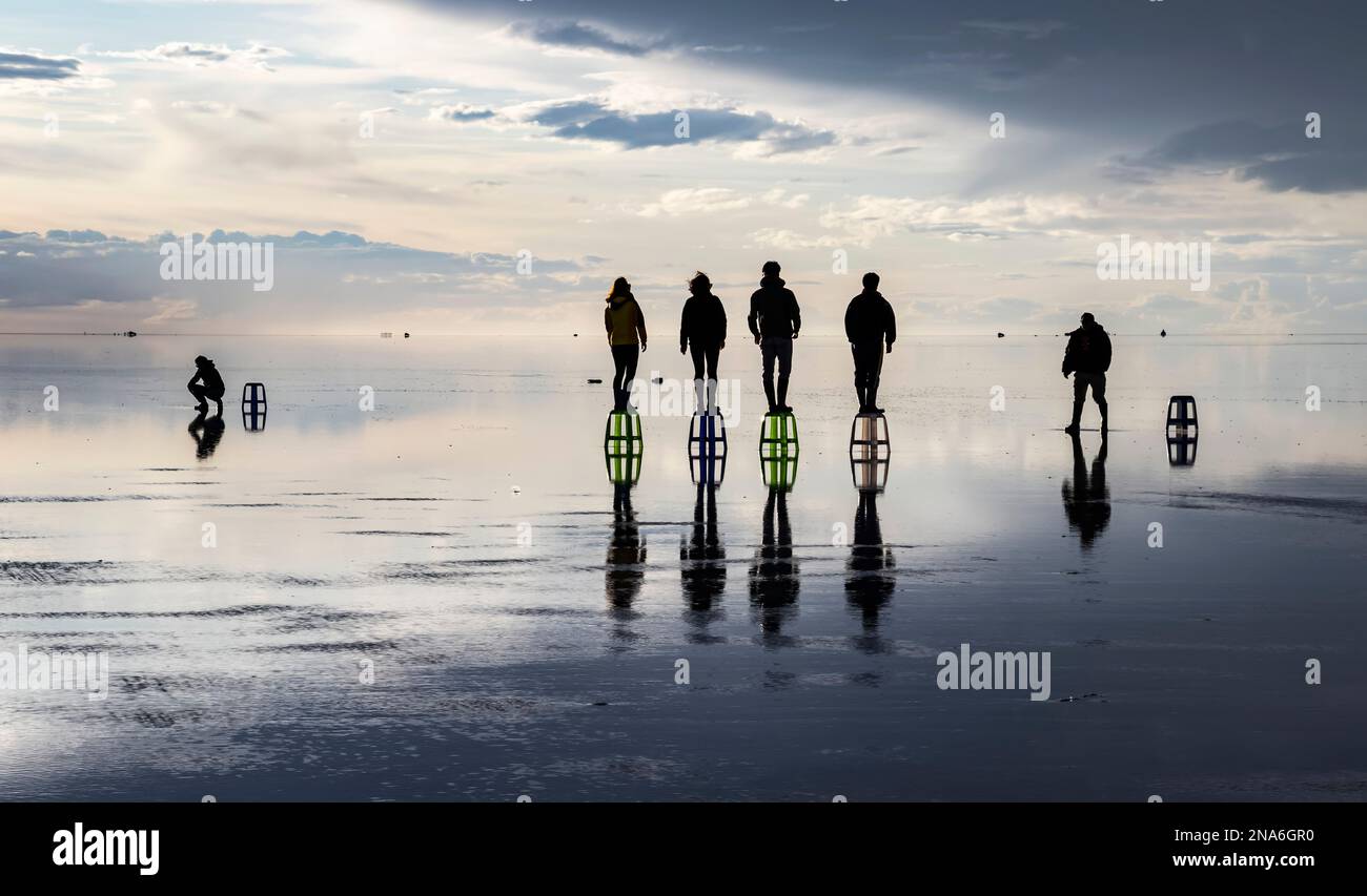 Tourists posing in the reflection during the wet season (December ...
